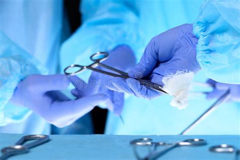 Surgeons Hands Holding Surgical Scissors And Passing Surgical Equipment