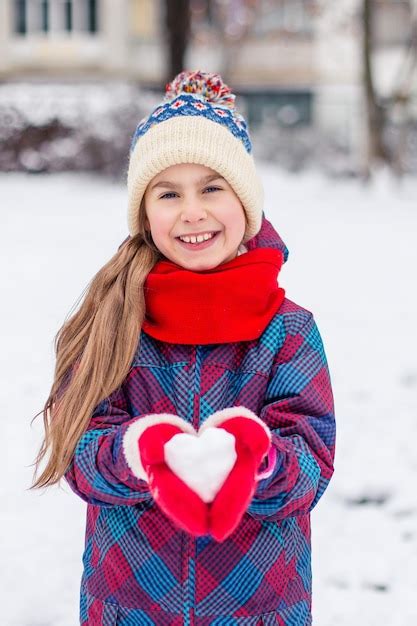 Una Chica Con Guantes Rojos Sostiene Una Bola De Nieve En Forma De