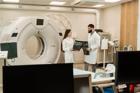 Ct 몸의 상세한 내부 이미지를 얻기 위한 컴퓨터 단층촬영 스캔 절차와 머리 뇌 및 척추의 종양에 대한 연구 환자 복부의 Ct 스캔 후 엑스레이에 대해 논의하는 두 의사