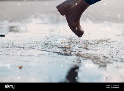 Woman Wearing Rain Rubber Boots Walking Running And Jumping Into Puddle