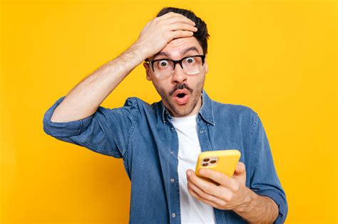 깜짝 놀란 코카서스 잘생긴 남자 깜짝 놀란 카메라보고 안경 손에 스마트 폰을 잡고 승리를 수상 예상치 못한 뉴스를 받았다 고립