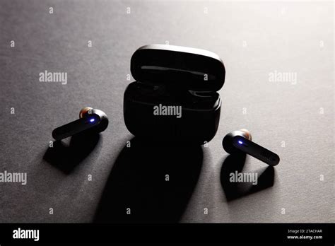 A Studio Shot Of A Pair Of Black Jbl Wireless Bluetooth Earphones Against A Dramatically Lit