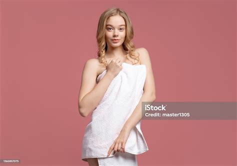 분홍색 스튜디오 배경에 고립 된 포즈를 취하는 흰색 수건에 어린 아름다운 슬림 소녀의 반 길이 초상화 자연의 아름다움 개념