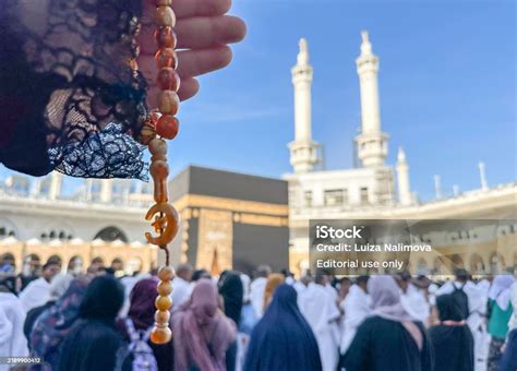 텍스트를 위한 공간이 있는 이슬람 배경 순례자의 여성 손에 초승달이 있는 이슬람 묵주 카바 신성한 모스크 하지를 수행하는 순례자들을 배경으로 합니다 Umrah에 대한 스톡