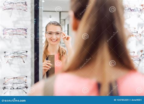 Young Woman Trying Fashionable Glasses In Optometrist Store Stock Image