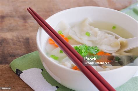 나무 테이블에 넣어 냅킨에 흰색 그릇에 만든 다진된 돼지고기 완탕 수프 아침 또는 점심 또는 저녁 식사에 대 한 명확한 수프 맛
