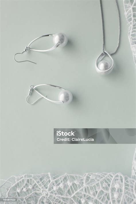 아름 다운 실버 반짝 진주 보석 세련 된 매력적인 귀걸이 절묘 한 레이스와 섬세 한 파스텔 배경에 체인 평평 하 고 상단 수직