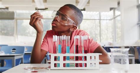 In School Boy Conducting Science Experiment With Test Tubes In