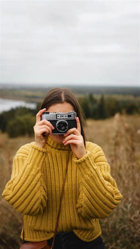 Девушка фотограф с пленочным винтажные фотоаппаратом в осеннем лесу