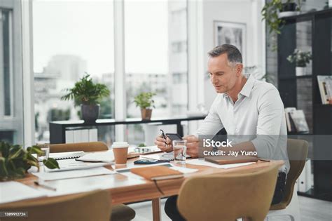 현대 사무실의 책상에서 스마트 폰을 사용하는 성숙한 사업가의 샷 55 59세에 대한 스톡 사진 및 기타 이미지 55 59세 남자 사업가 Brand Name Smart