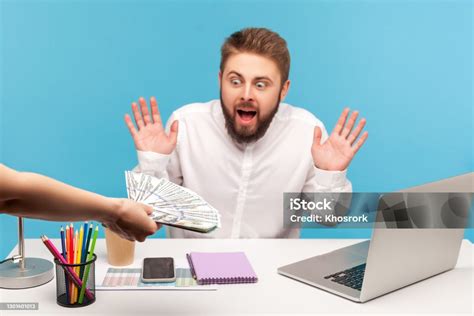 수염을 기르고 100 달러 지폐의 큰 합계로 손을 보고 비명을 지르는 충격을 받은 남자 사무실 노동자 뇌물을 받고 30 34세에