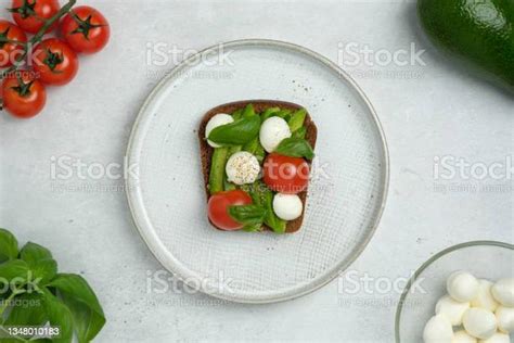 아보카도 체리 토마토 모짜렐라 바질 잎이 있는 건강한 채식 오픈 샌드위치 맨 위 보기입니다 건강한 식습관 0명에 대한 스톡 사진