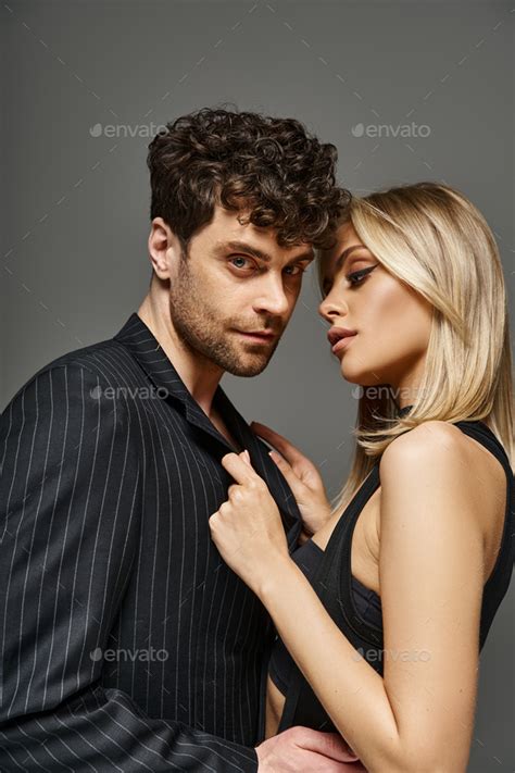 Blonde Woman In Black Dress Seducing Elegant Man In Evening Attire On