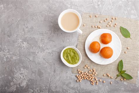 회색 콘크리트 배경에 민트 처트니와 흰색 접시에 전통적인 인도 사탕 Gulab Jamun 상단보기 복사 공간 평평한 평신도 0