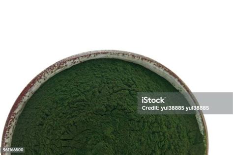 조류 Spirulina입니다 Spirulina 파우더 클로즈업입니다 Spirulina는 흰색 바탕에 고립 된 둥근 세라믹 접시에