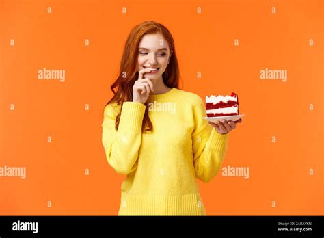 Cheerful And Satisfied Happy Redhead Woman Have Cheat Day Eating Delicious Food Holding Tasty