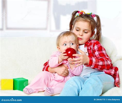 Portrait Of An Older Sister Hugging Her Younger Sister Royalty Free