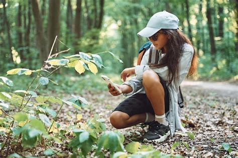 Premium Photo Using Smartphone To Make Photos Girl Is In The Forest