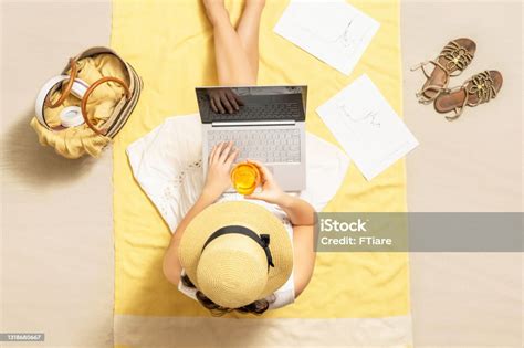 사업가 프리랜서 는 모래 해변의 비치 타월에 앉아 그래픽과 차트와 노트북에서 작업 주스를 마시는 여름 방학 공중 보기 거래자에