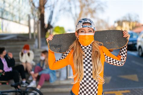 그녀의 목 뒤에 스케이트 보드를 들고 보호 얼굴 마스크를 가진 젊은 여성의 초상화 16 17 살에 대한 스톡 사진 및 기타 이미지 16 17 살 20 24세 30
