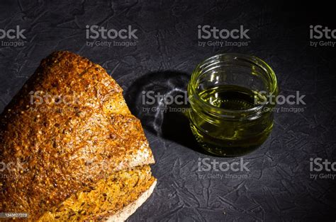 아마 양귀비 씨앗 참깨 기장 호박 해바라기 씨 유리 항아리에 올리브 오일 검은 배경 하드 라이트 낮은 키에 사진 소박한 천연 효모가없는 빵 조각 갈색에 대한 스톡 사진 및