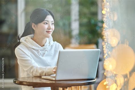 아시아 한국의 카페 테이블에 앉아서 노트북을 바라보며 강의를 듣거나 숙제 또는 일을 하는 젊은 여자 대학생 모델 Photos