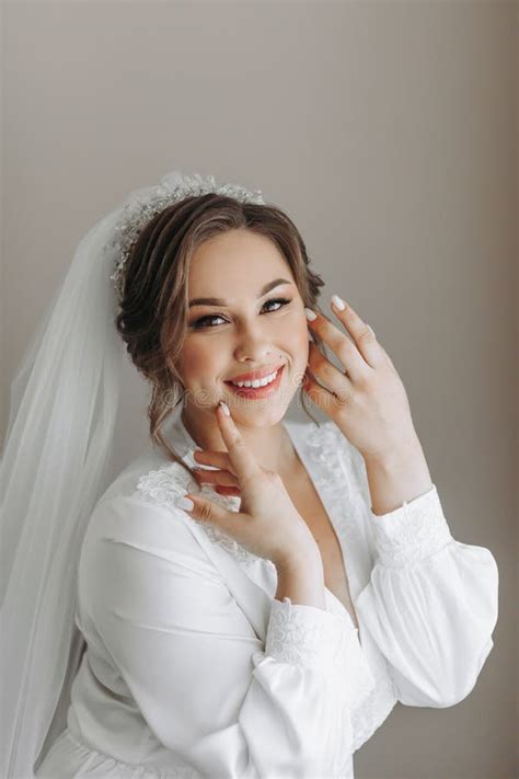 A Beautiful Bride In A Robe And Lush Veil With Beautiful Hair And