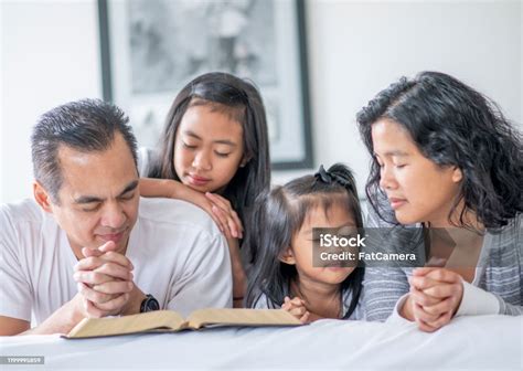 Keluarga Filipina Berdoa Dan Membaca Bersama Di Foto Stok Tempat Tidur Foto Stok Unduh Gambar
