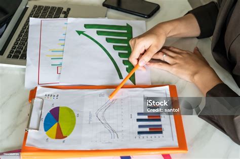테이블에 통계 그래프와 마케팅 전략을 분석 하는 경제여성 가리키기에 대한 스톡 사진 및 기타 이미지 가리키기 개념 그래프