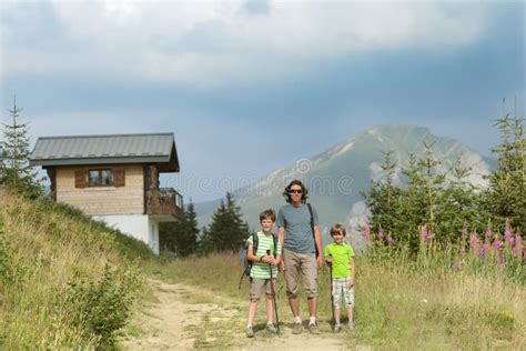 Счастливый отец семьи и 2 мальчика идут в горы Стоковое Фото изображение насчитывающей актеров