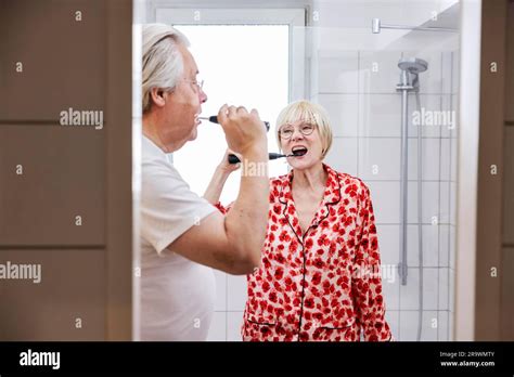 Elderly Couple Brush Their Teeth Together In The Bathroom Cologne