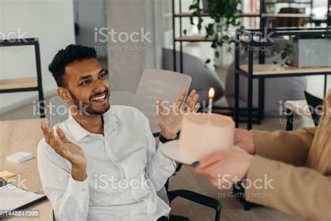 젊은 힌두교 남자가 케이크에 촛불을 불고 동료들과 생일 축하 행사를하면서 소원을 빌려고합니다 사무실에서 생일을 축하하는 동료들 20 24세에 대한 스톡 사진 및 기타 이미지