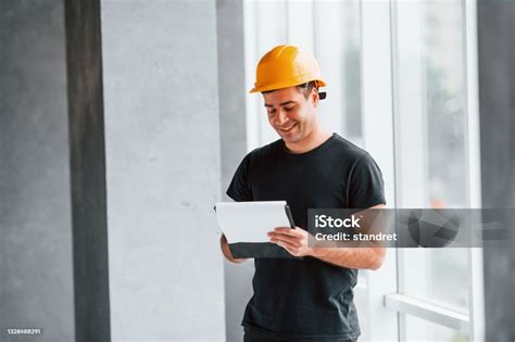 메모장이 있는 실내에 서 있는 노란 단단한 모자를 쓴 남성 노동자 또는 엔지니어 부귀에 대한 스톡 사진 및 기타 이미지 부귀 수리 엔지니어 Istock