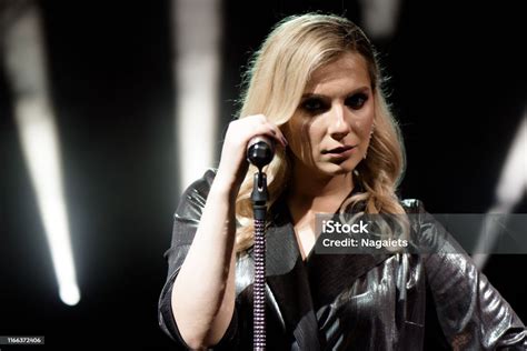 긴 머리를 한 여성 가수가 스탠드와 함께 마이크를 들고 노래를 부른다 Fashion Show에 대한 스톡 사진 및 기타 이미지 Fashion Show Film