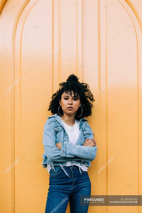Young African American Woman In Jeans And Denim Jacket Leaning On