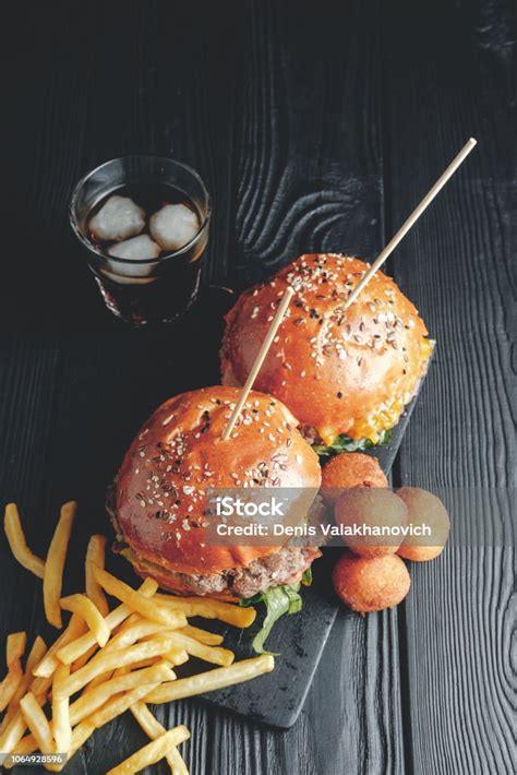 집에서 맛있게 햄버거 나무 보드 치즈 볼에 길거리 음식 패스트 푸드입니다 감자 튀김와 콜라의 유리 건강에 좋지 않은 음식에 대한
