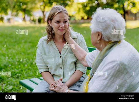 Worried Senior Grandmother Comforting Grown Up Granddaughter When