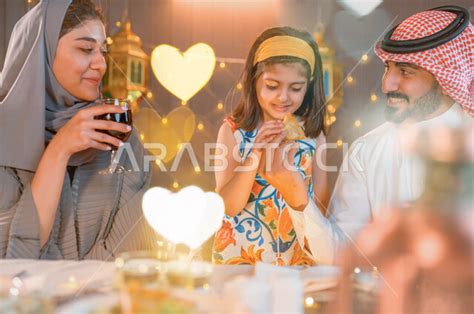 عائلة عربية خليجية مستمتعة بتناول الافطار الرمضاني ، البهجة والسرور