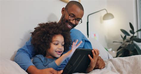 아동 발달을 위해 가정의 거실 소파에서 아버지와 아들과 함께 교육 게임 또는 태블릿 아파트에서 편부모 남자와 소년 아이와 함께