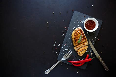 로즈마리 후추 케첩와 어두운 나무 배경에 향신료 슬레이트 접시에 치킨 필 레 구이 최고의 볼 수 있습니다 플랫이 하다 공간 복사