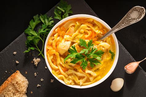 숟가락 빵 조각 샐러리 가지 마늘로 어두운 소박한 질감으로 위에서 찍은 닭고기와 국수 수프 접시의 오버 헤드 사진 0명에 대한