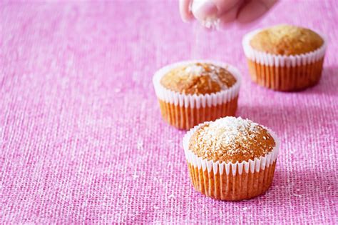 수 제 Vhomemade 코코넛 가루와 바닐라 머핀입니다 핑크 배경입니다 공간에 복사 합니다 선택적 초점입니다 코코넛 가루의 좋은 아침 Conceptanilla 머핀 핑크