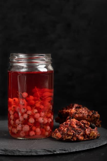 Premium Photo Jar Of Red Currant Compote And Oatmeal Cookie Against Dark