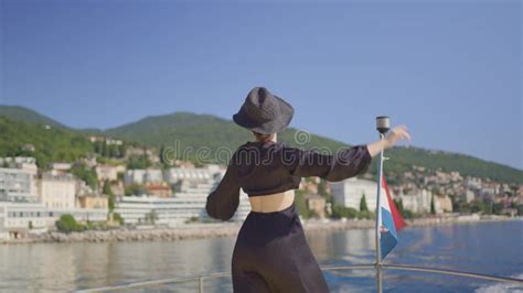 A Woman Is Enjoying The Stunning Coastal City View While Resting On A Luxurious Yacht Stock