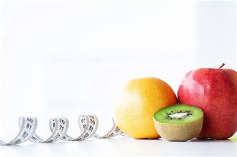 다이어트입니다 피트 니스 및 건강 식품 다이어트 개념 야채와 함께 균형 잡힌 다이어트입니다 신선한 녹색 야채 흰색 바탕에 테이프를 측정 합니다 근접 촬영 가냘픈에 대한 스톡