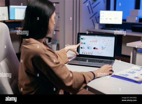 Busy Employee Pointing At Graph Working To Finish A Deadline Wprlomg