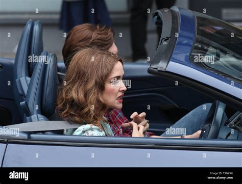 Cast Members Rose Byrne And Domhnall Gleeson Driving In An Aston Martin