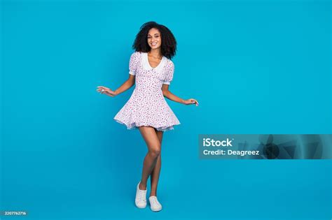 화려한 파란색 배경에 포즈를 취하며 기쁨과 매력을 표현하는 세련된 꽃무늬 드레스를 입은 아름다운 젊은 여성 25 29세에 대한 스톡 사진 및 기타 이미지 Istock