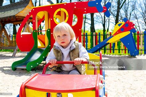 귀여운 재미 금발 작은 어린 유아 아이 소년 앉아서 장난감 자동차 놀이터에서 자동차에 타고 어린이 신체적 정서적 발달 및 어린 시절의 보육 유치원 개념 2 3 살에 대한