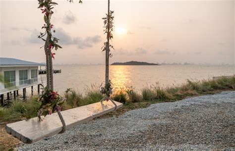Premium Photo The Wooden Swing By The Sea Sunset